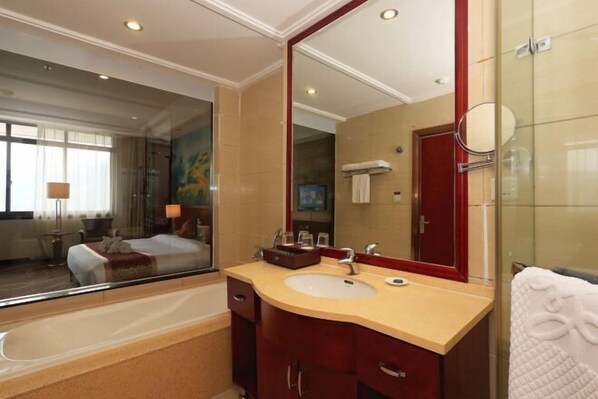 Uma casa de banho moderna com um espelho grande, lavatório e banheira.