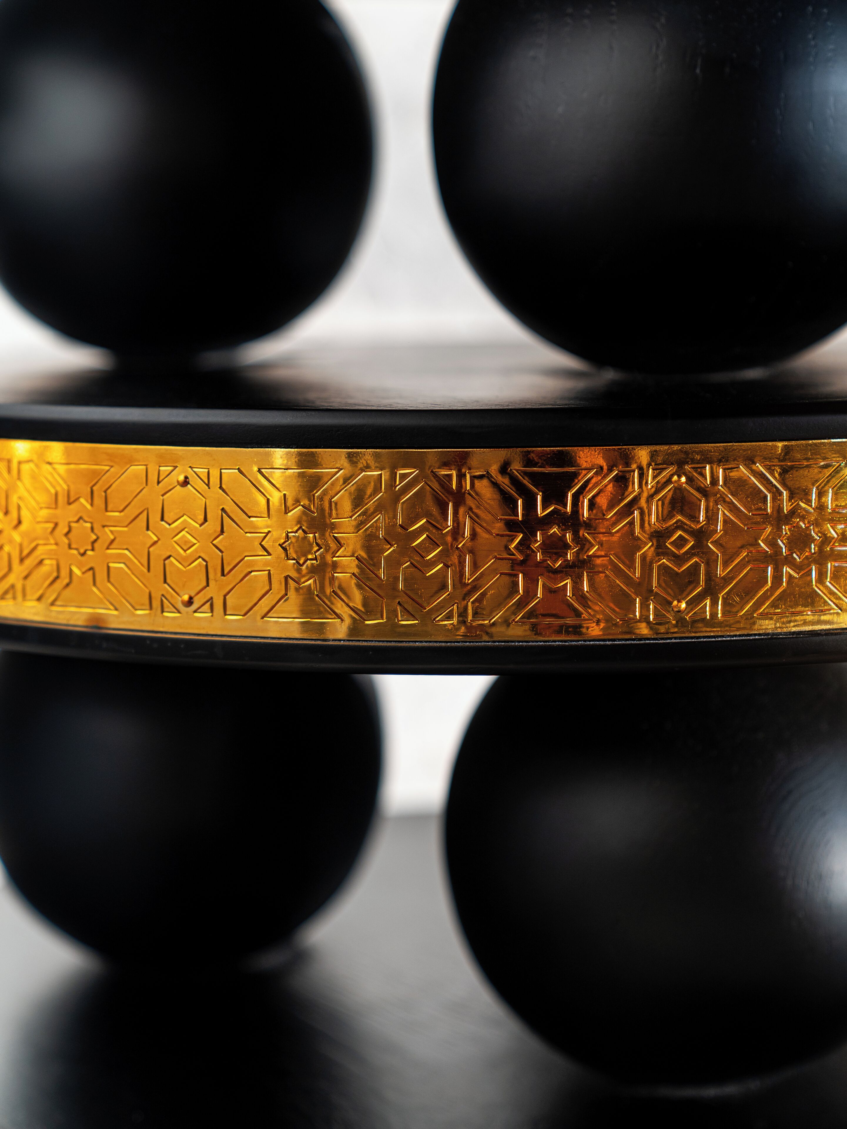 Close-up de um objeto preto e dourado com padrões intrincados.