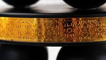 Close-up de um objeto preto e dourado com padrões intrincados.