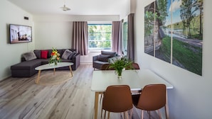 Uma sala de estar moderna com sofá, mesa de centro e área de jantar.