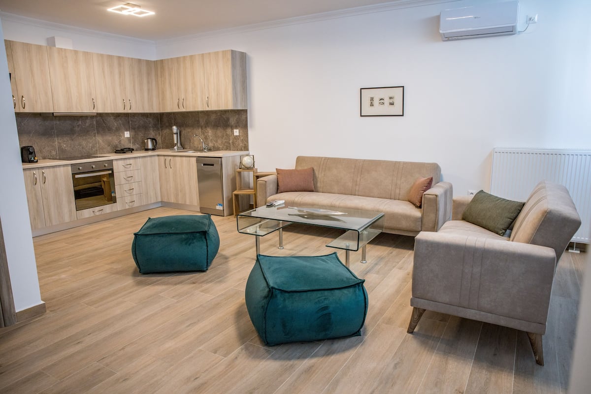 Um apartamento moderno com cozinha, sala de estar e mesa de jantar.
