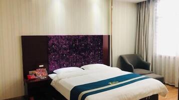Quarto de hotel com cama, mesa de cabeceira, cadeira e janela com cortinas.