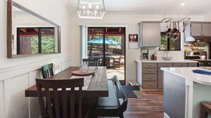 Cozinha moderna com área de refeições, janelas amplas e vista para o exterior.