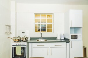 Um frigorífico, um micro-ondas, um forno, uma cafeteira/bule 