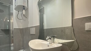Uma casa de banho moderna com lavatório independente, sanita e cabine de duche.