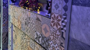 Corredor com ladrilhos estampados e uma decoração festiva com um boneco de neve e luzes.