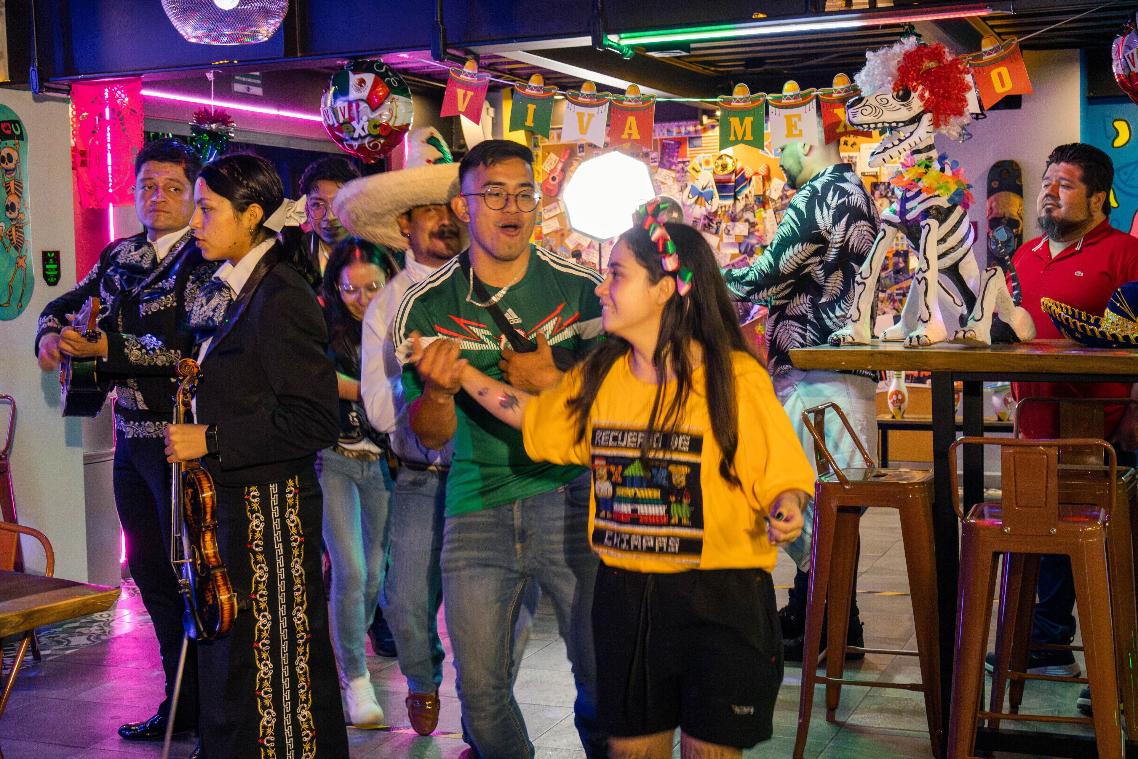 Um evento animado em ambiente interno com pessoas dançando e socializando.