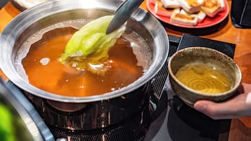 Um pote quente com uma concha, uma tigela de sopa e um prato de comida.