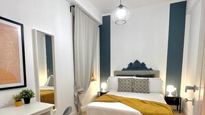 Um quarto moderno com cama, mesas de cabeceira, escrivaninha e uma cadeira.