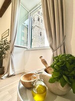 Uma bancada de cozinha com uma tigela de madeira, um frasco de vidro com óleo e uma planta verde.