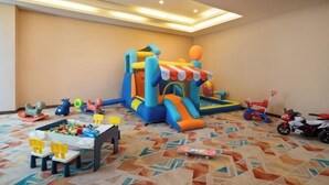 Espaço infantil com pula-pula inflável, piscina de bolinhas e diversos brinquedos.