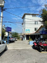 Um edifício com uma placa indicando 'Casa da Praia' e um quadriciclo vermelho estacionado.