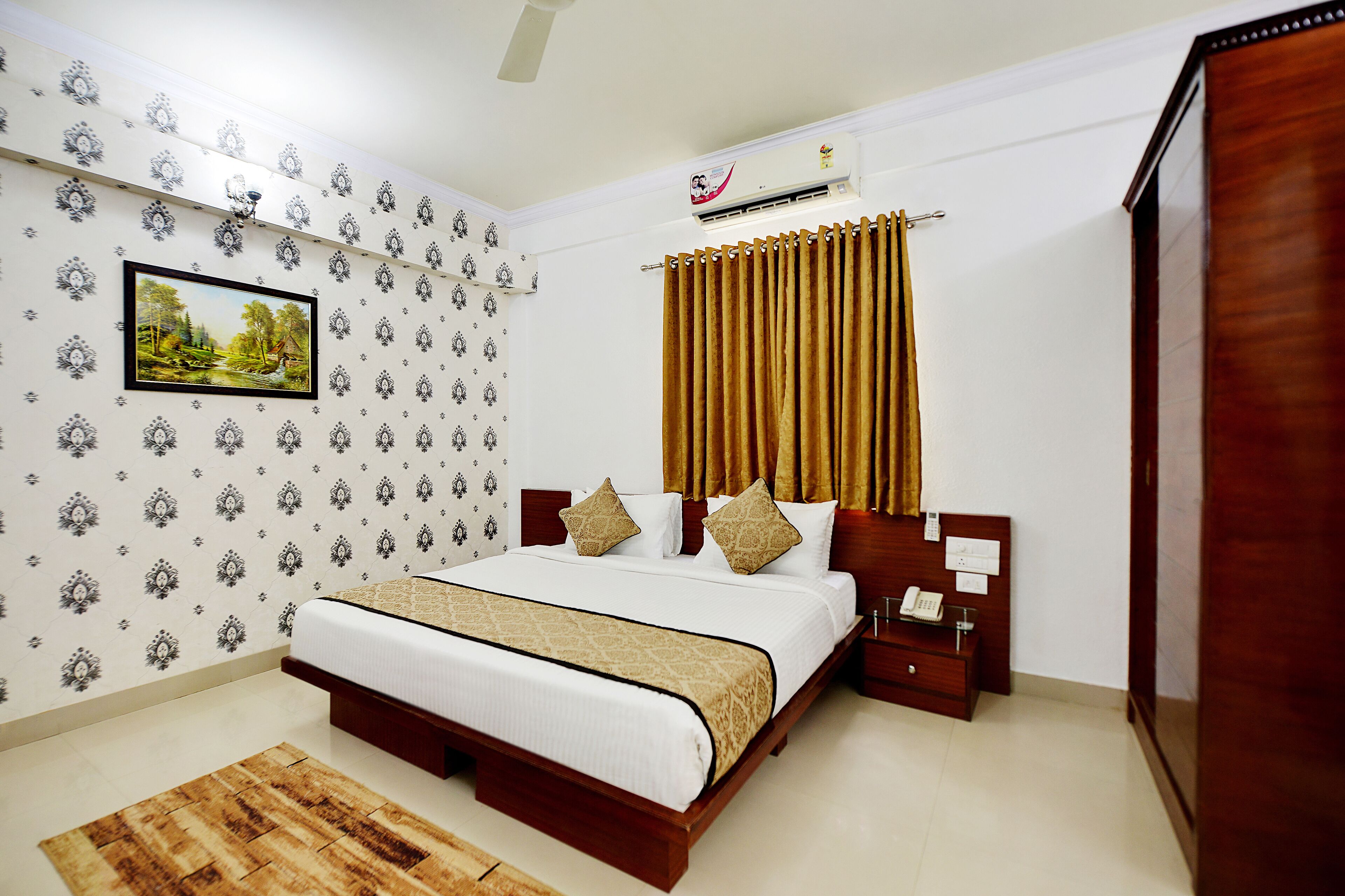 Quarto com cama grande, cabeceira de madeira, mesa de cabeceira, ar condicionado fixado na parede e quadro emoldurado.