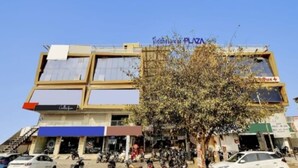Um edifício de vários andares com diversas lojas no andar térreo.