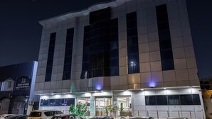 Um edifício moderno com fachada plana, grandes janelas e uma entrada bem iluminada.