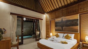Quarto com cama grande, cabeceira de madeira e pintura de uma cena tradicional.
