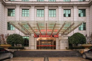 Um edifício com entrada coberta e degraus que levam até ele, com uma placa com caracteres chineses.
