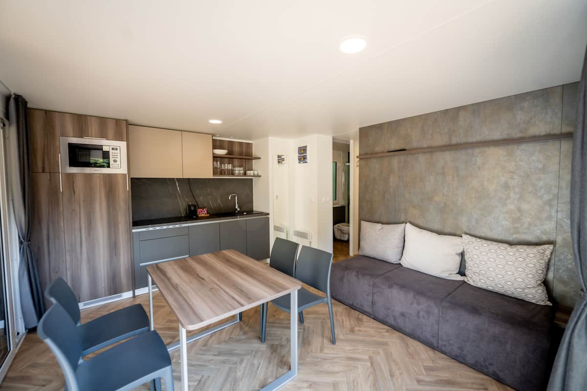 Um espaço compacto com cozinha compacta, área de refeições e sofá.
