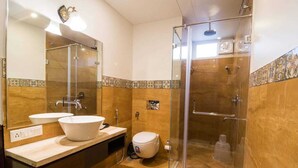 Casa de banho com duas pias, sanita e cabine de duche com vidro.