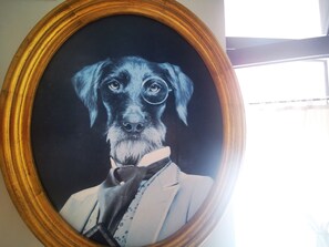 Retrato emoldurado de um cão vestindo terno.