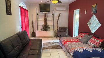 Apartamento Deluxe, 1 quarto, kitchenette, no rés do chão | Sala de estar | Televisor LCD de 50 polegadas com canais digitais, televisor