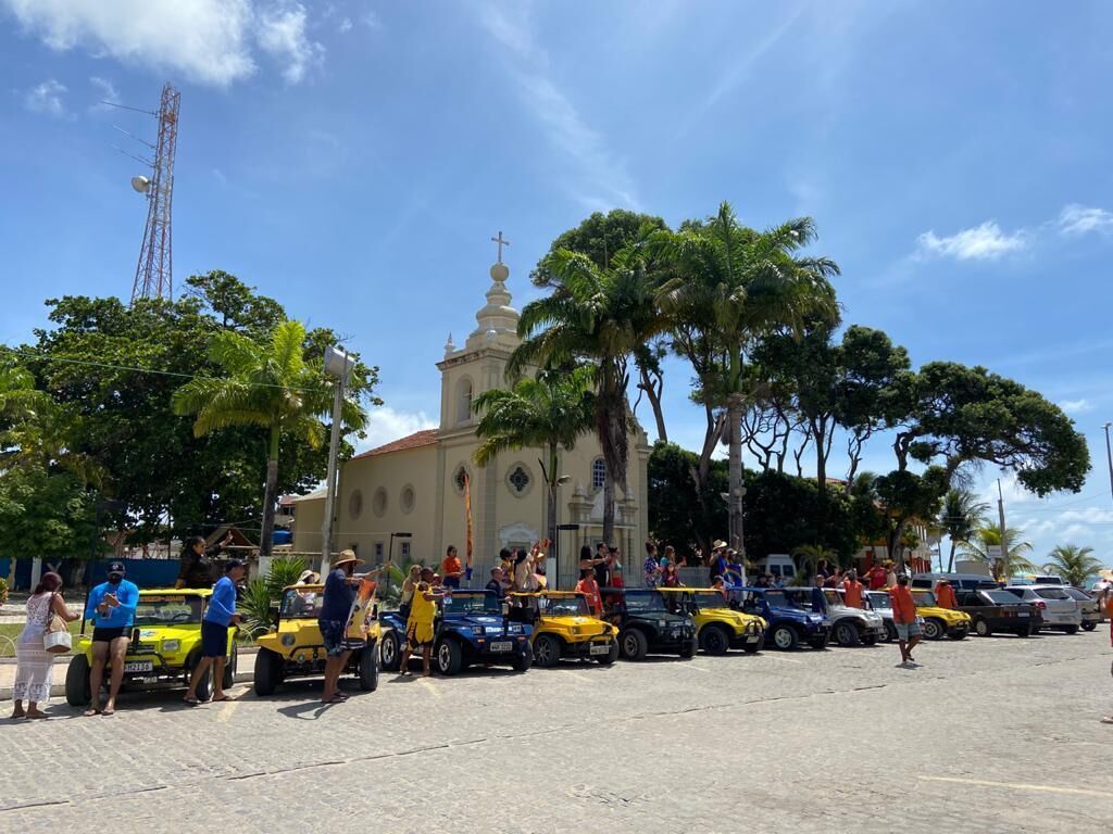 Uma igreja com um campanário e palmeiras ao fundo.