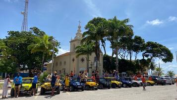 Uma igreja com um campanário e palmeiras ao fundo.
