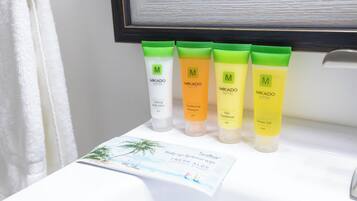 Uma bancada de banheiro com quatro produtos de skincare Mikado SPF3 e um folheto de viagens.