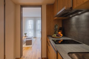 Uma cozinha moderna com armários de madeira, um exaustor de aço inoxidável e uma fruteira no balcão.