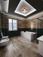 Suite de Luxo | Casa de banho | Uma banheira de hidromassagem, um chuveiro fixo, um secador de cabelo 