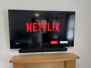Uma televisão exibindo o logotipo da Netflix, com botões 'Entrar' e 'Começar'.