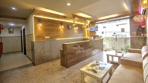Um lobby moderno com balcão de recepção, área de estar e vista para o exterior.