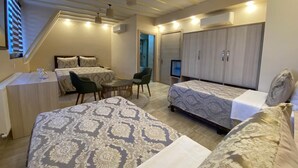 Quarto com duas camas, uma escrivaninha, uma cadeira e um guarda-roupa.