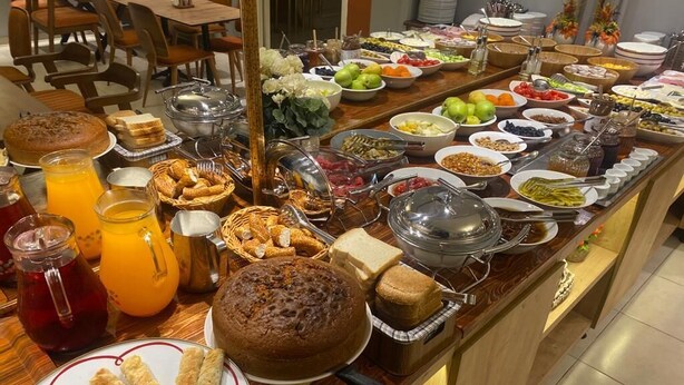Um buffet com diversos alimentos, incluindo frutas, vegetais e produtos de panificação.