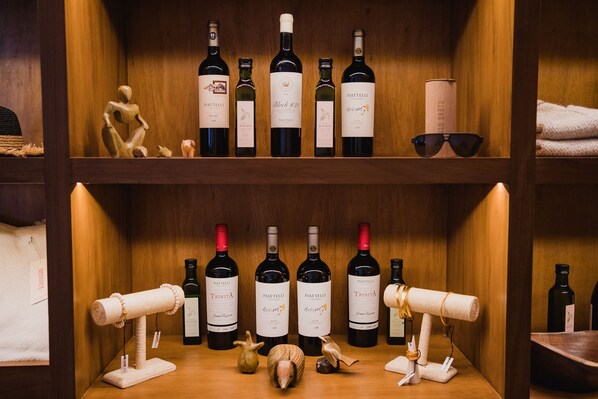 Estante de madeira com garrafas de vinho e um arranhador para gatos.