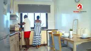 Uma cozinha com duas pessoas, uma mesa de jantar com cadeiras e uma janela.