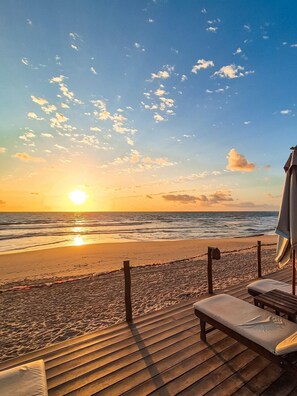 Na praia, espreguiçadeiras, guarda-sóis de praia, toalhas de praia 