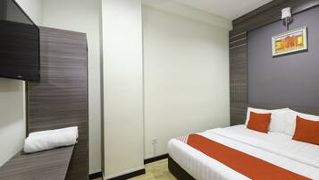 Quarto de hotel moderno com uma cama, uma televisão de tela plana e um quadro na parede.