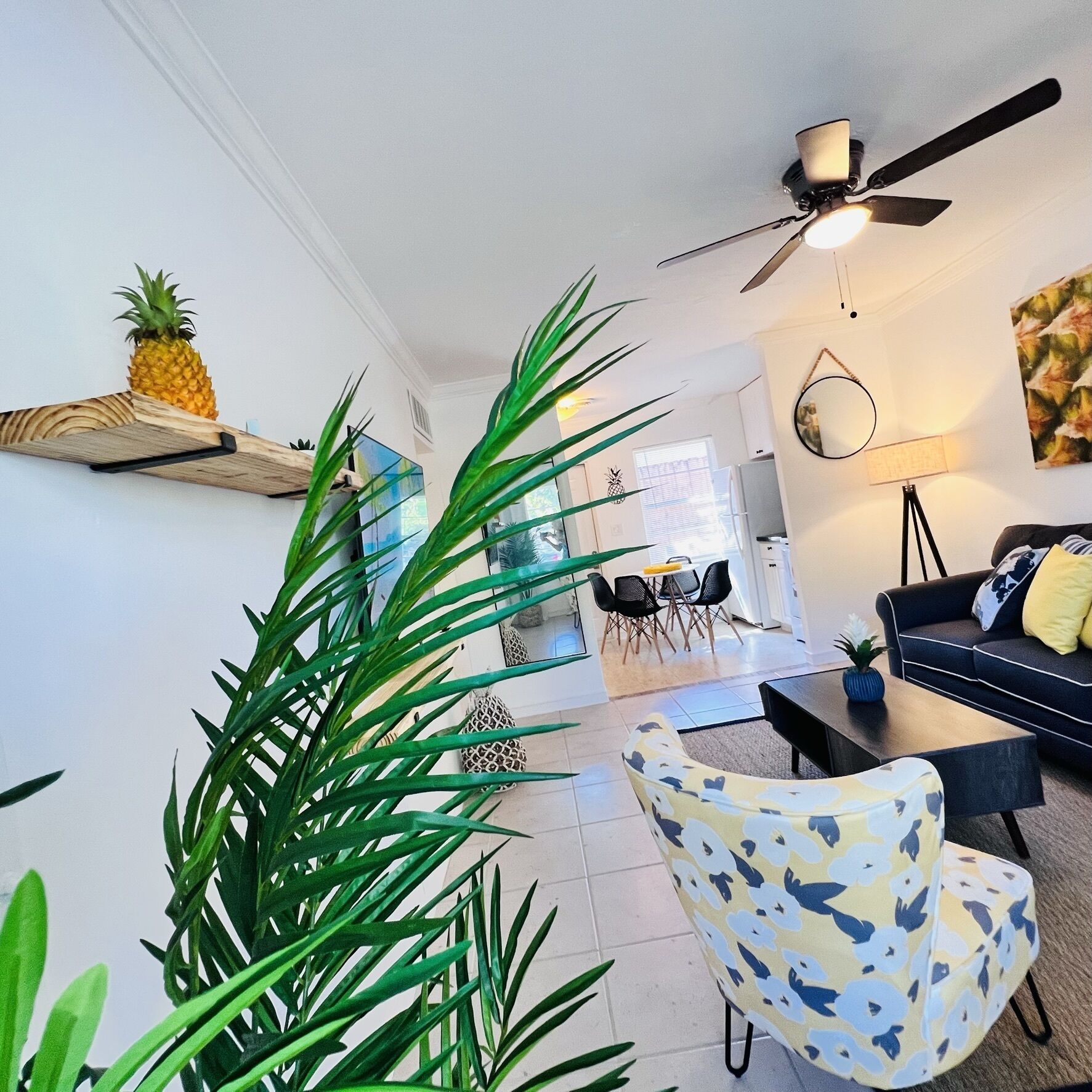 Uma sala de estar moderna com um sofá, uma mesa de centro e uma área de jantar com cadeiras.