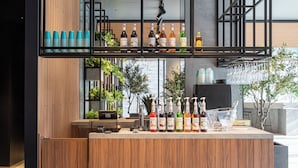 Uma área de bar com lambris de madeira, variedade de garrafas, copos e balcão.