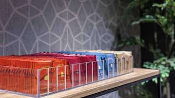 Estante de madeira com caixas de chá organizadas em recipientes transparentes.