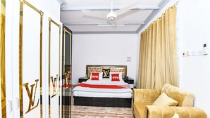 Quarto de hotel com uma cama, um sofá e um guarda-roupa com o logotipo Louis Vuitton.