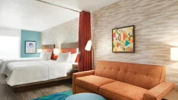 Quarto de hotel com cama, sofá, um pequeno banquinho e parede com textura.