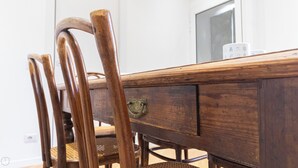 Uma mesa de jantar de madeira com uma gaveta e um puxador de metal.