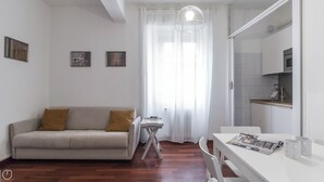 Uma sala moderna com um sofá, uma mesinha e um espaço de jantar.
