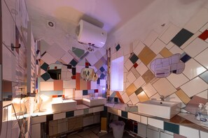 Casa de banho com várias pias, um espelho e um ventilador de teto.