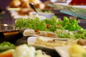 Buffet com diversos pratos, incluindo frutos do mar e saladas.
