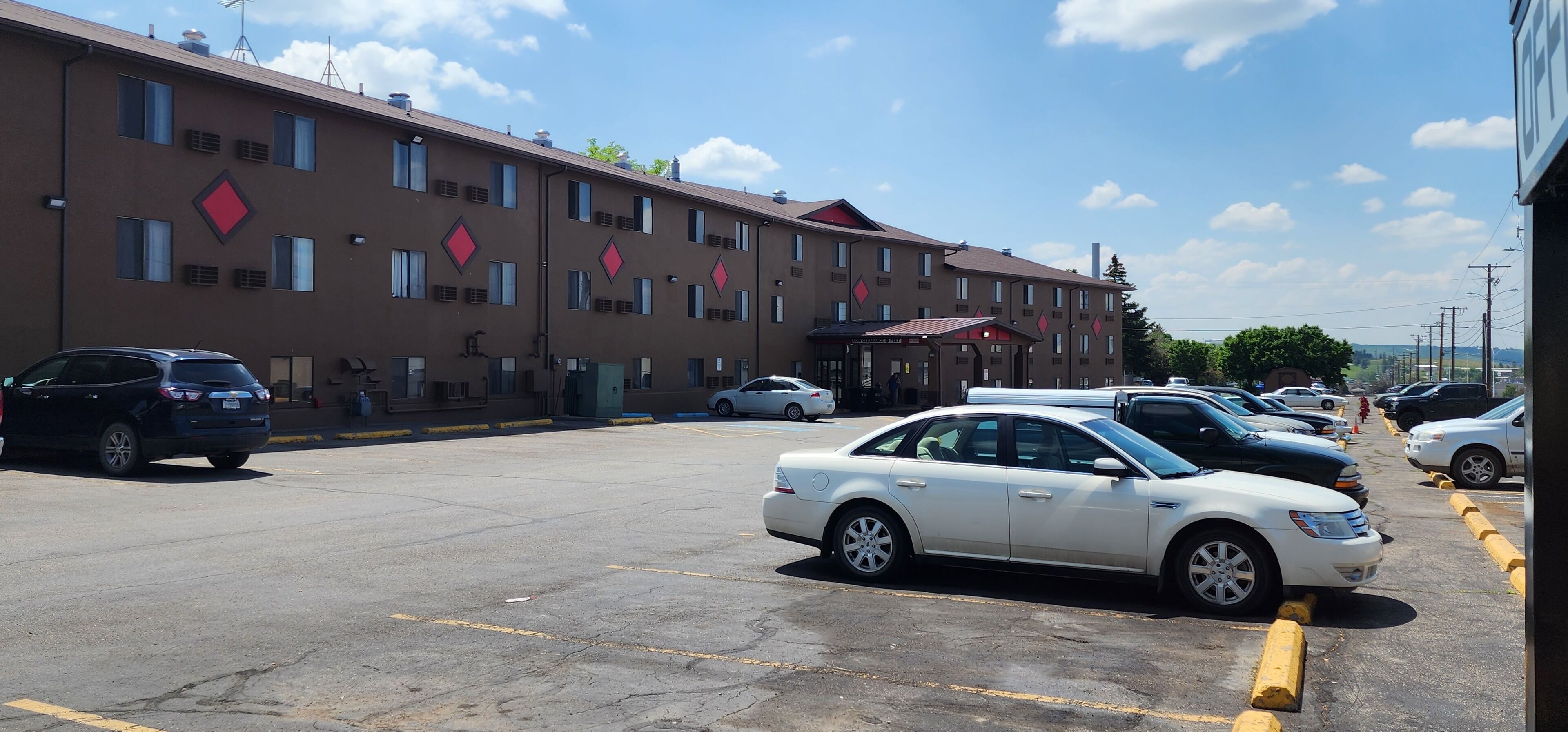 Um hotel com vários andares e estacionamento.