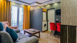 Uma sala de estar moderna com um sofá, uma mesa de centro e uma máquina de lavar roupa.
