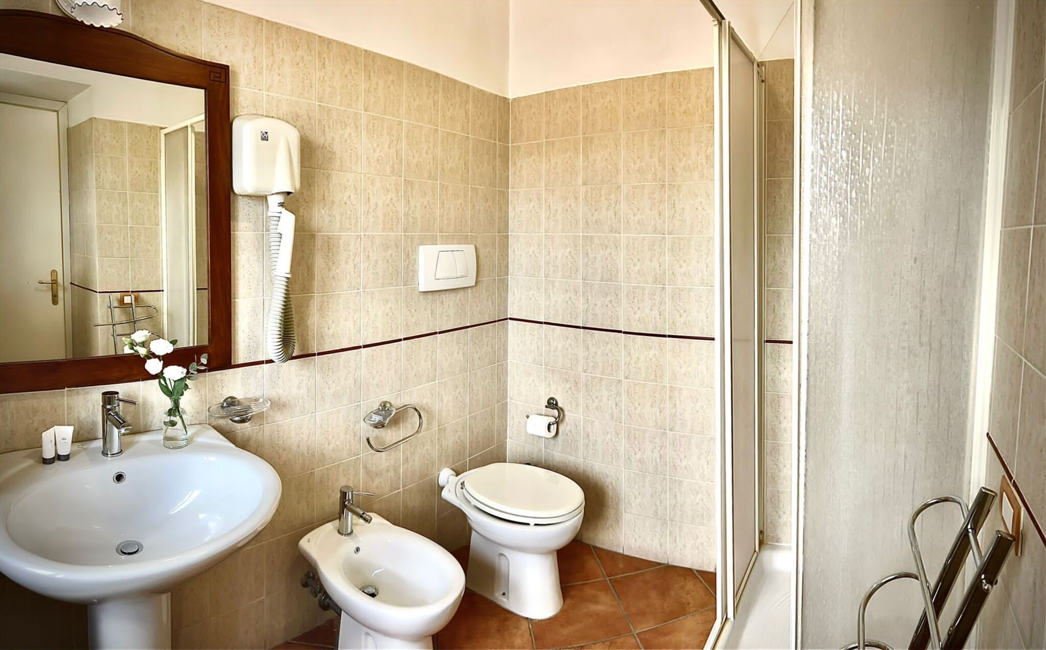 Casa de banho com lavatório, bidé, sanita e zona de duche.